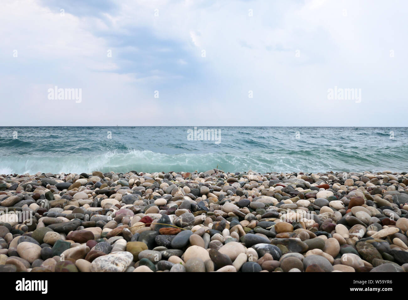 Pebble beach and blue sea Stock Photo - Alamy