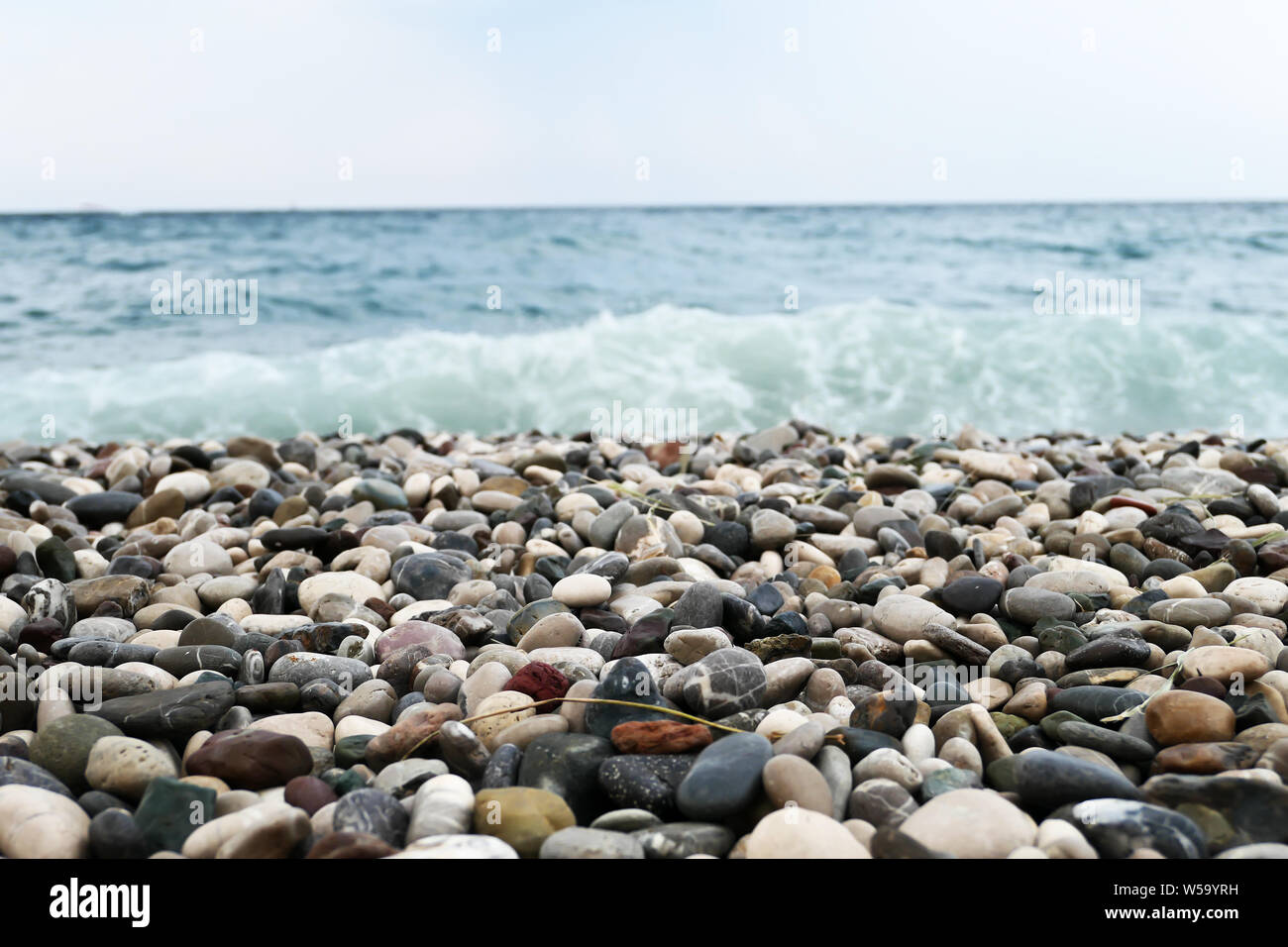 Pebble beach and blue sea Stock Photo - Alamy