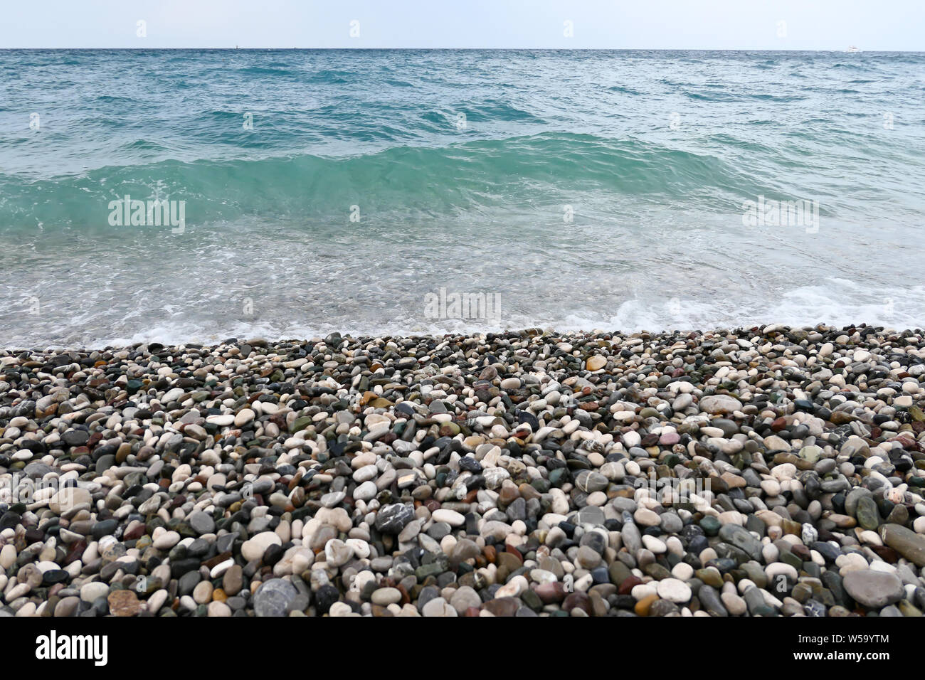 Pebble beach and blue sea Stock Photo - Alamy