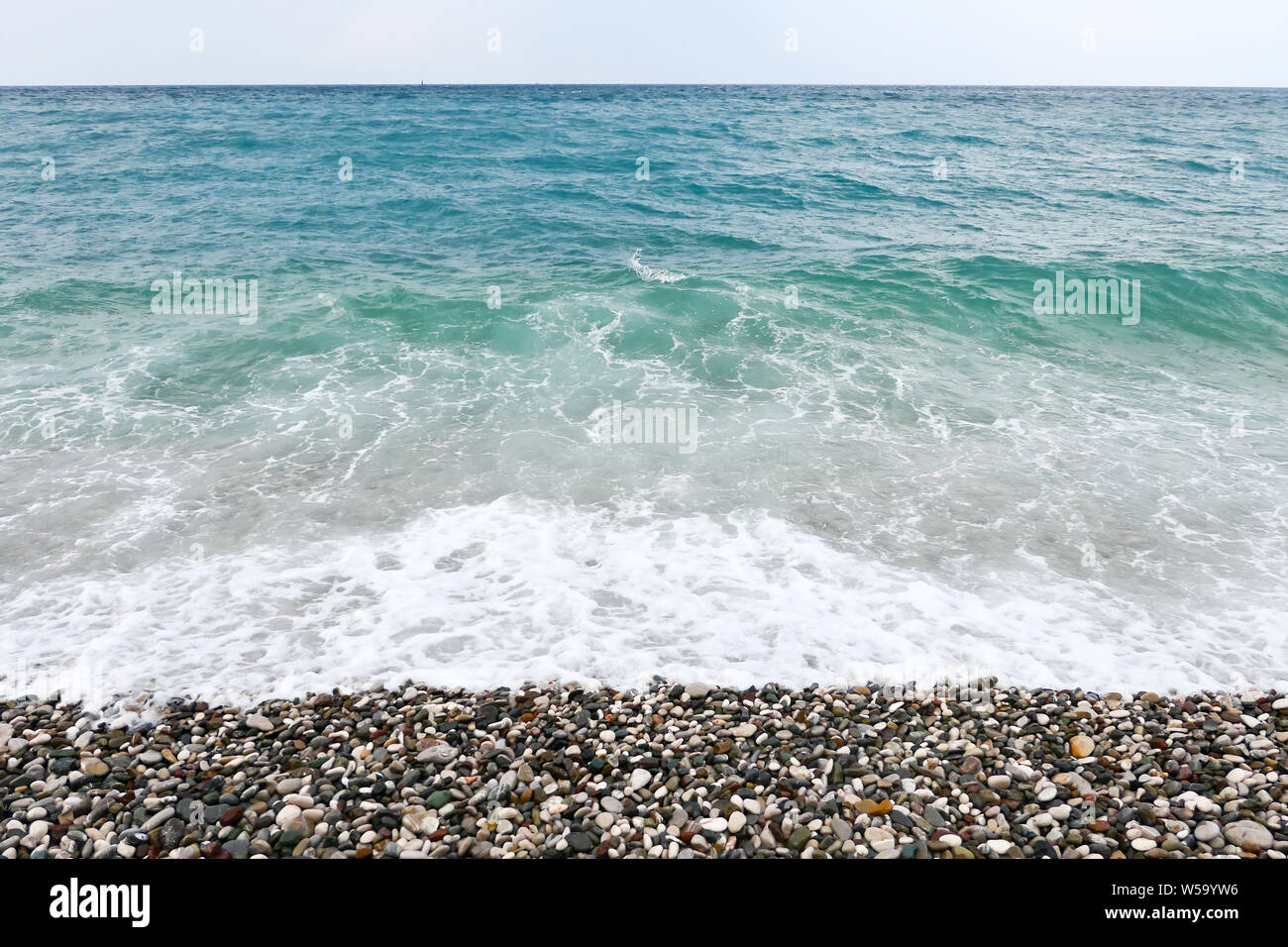 Pebble beach and blue sea Stock Photo - Alamy