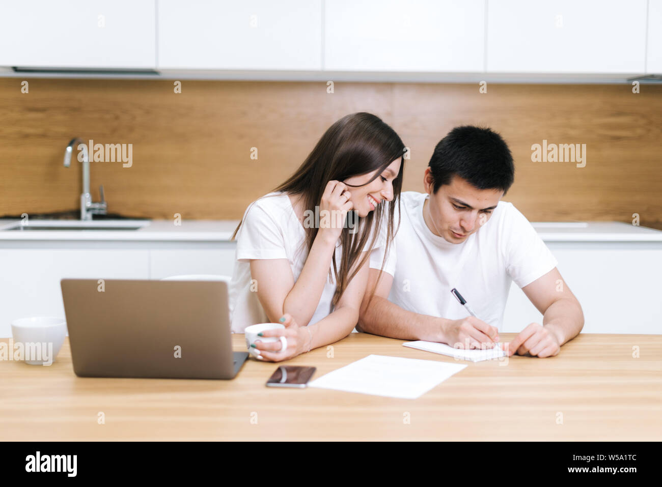Happy smiling couple makes notes in notebook.Young man and woman ...