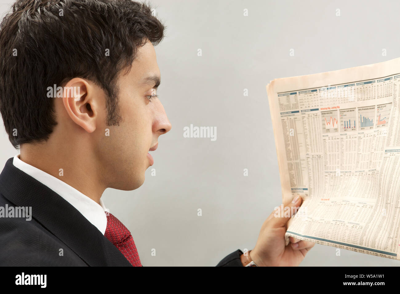 Indian businessman reading financial newspaper Stock Photo - Alamy
