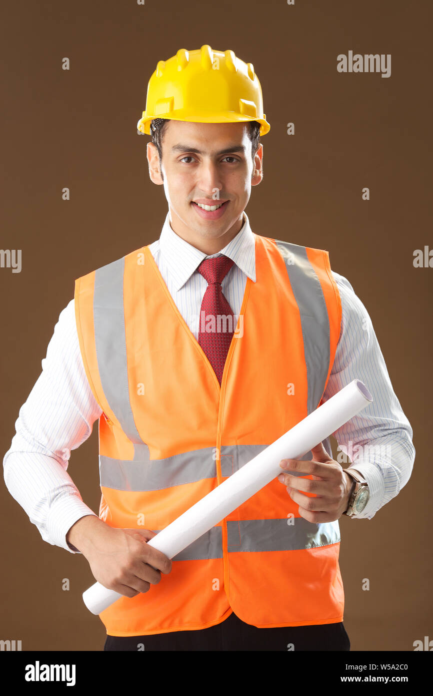 Male architect holding a blueprint and smiling Stock Photo - Alamy