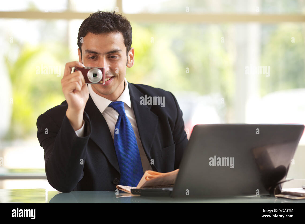 Businessman photographing with digital camera in an office Stock Photo ...