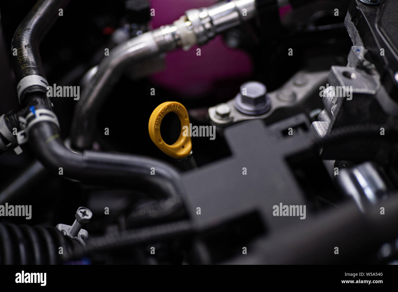 Yellow oil dipstick in car engine. Measuring level of engine oil Stock ...