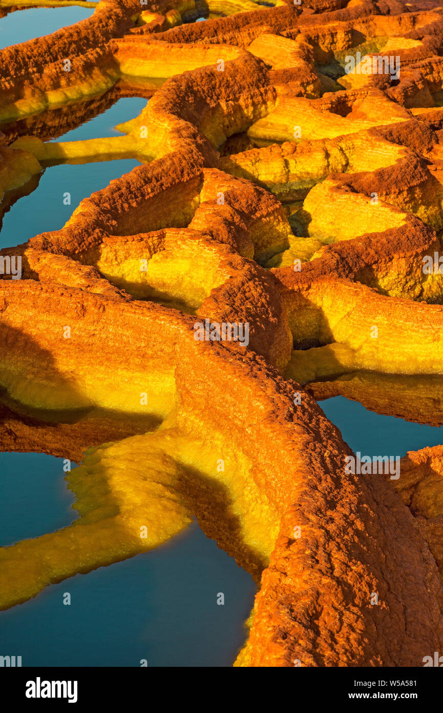 Rust-colored salt structures in an acid brine pool, geothermal field of ...