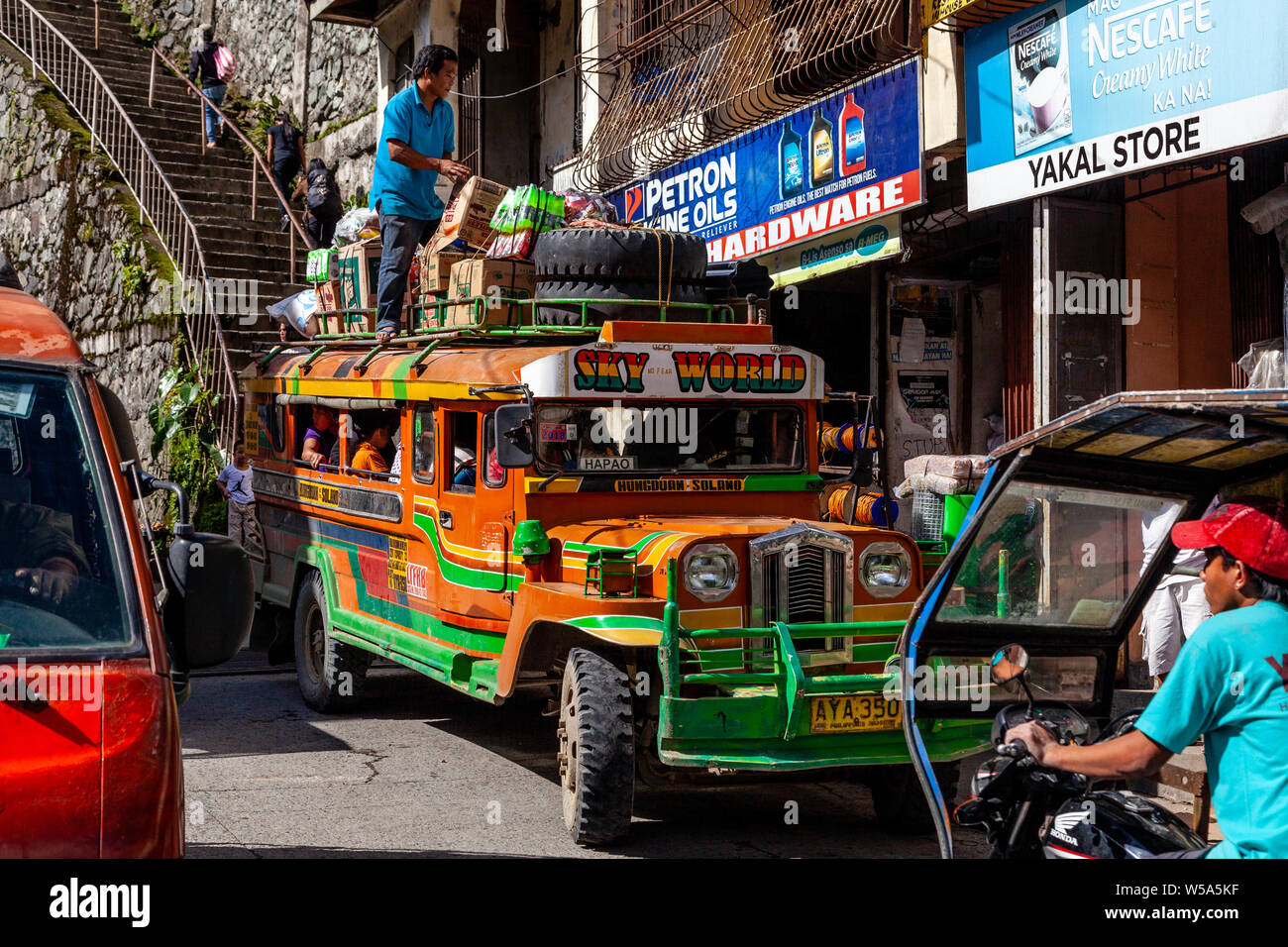 A Man Stands On The Roof Of A Jeepney Bus Unloading Boxes, Banaue ...