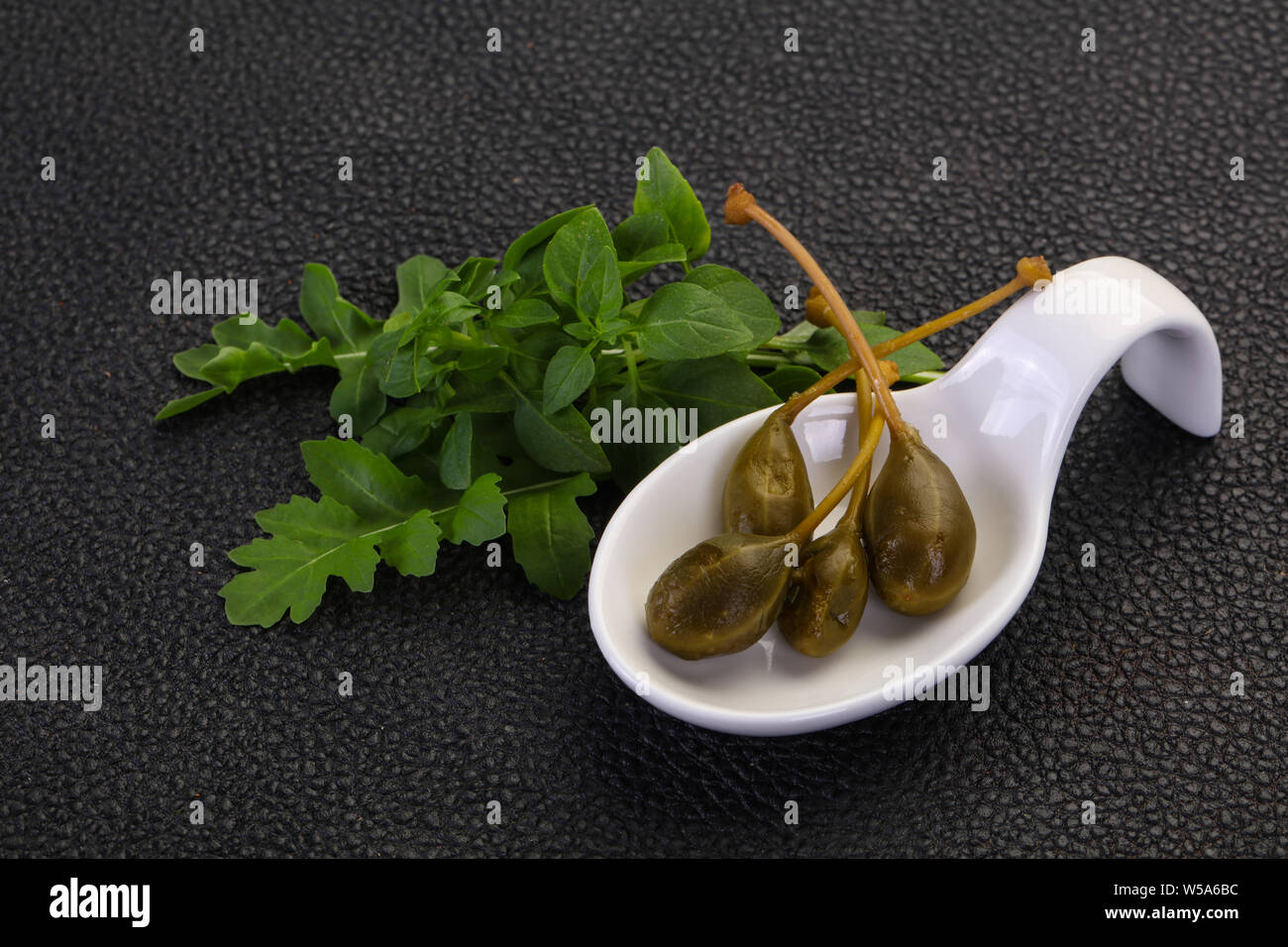 Pickled Capersberries in the bowl with basil Stock Photo - Alamy