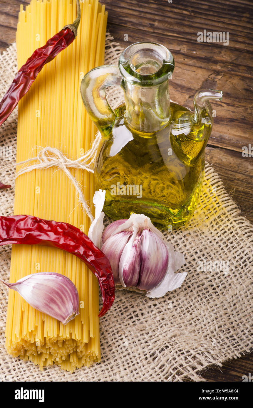 still life. Raw spaghetti with garlic cloves, some dried hot peppers ...