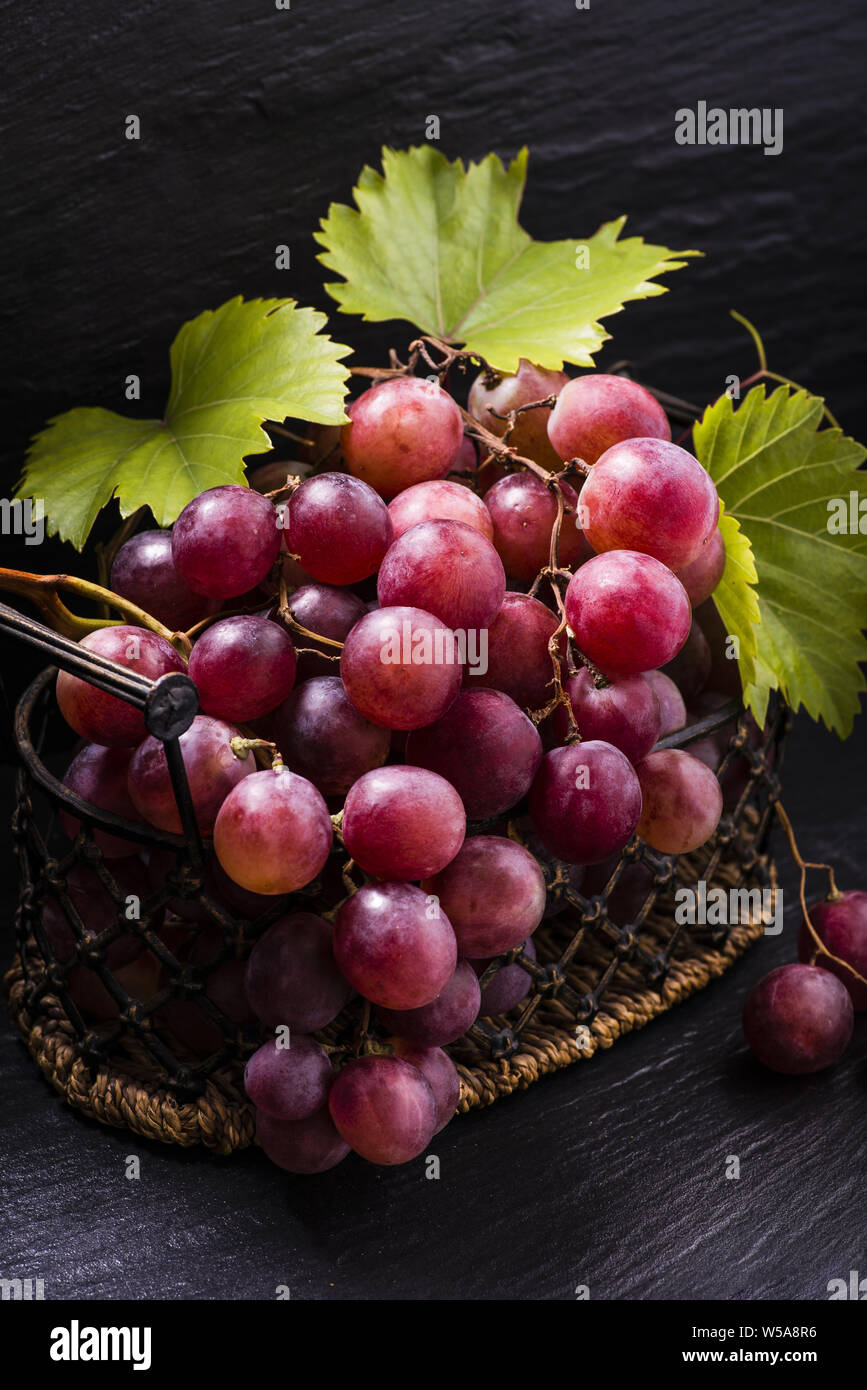 in the vintage basket red table grapes with leaves .still life Stock ...