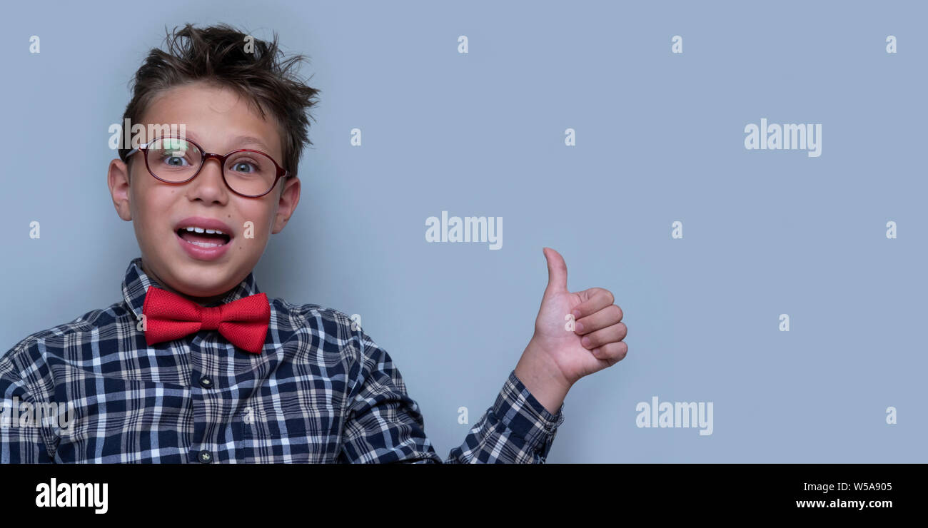 Young boy giving thumbs up portrait on violet background. Child ...