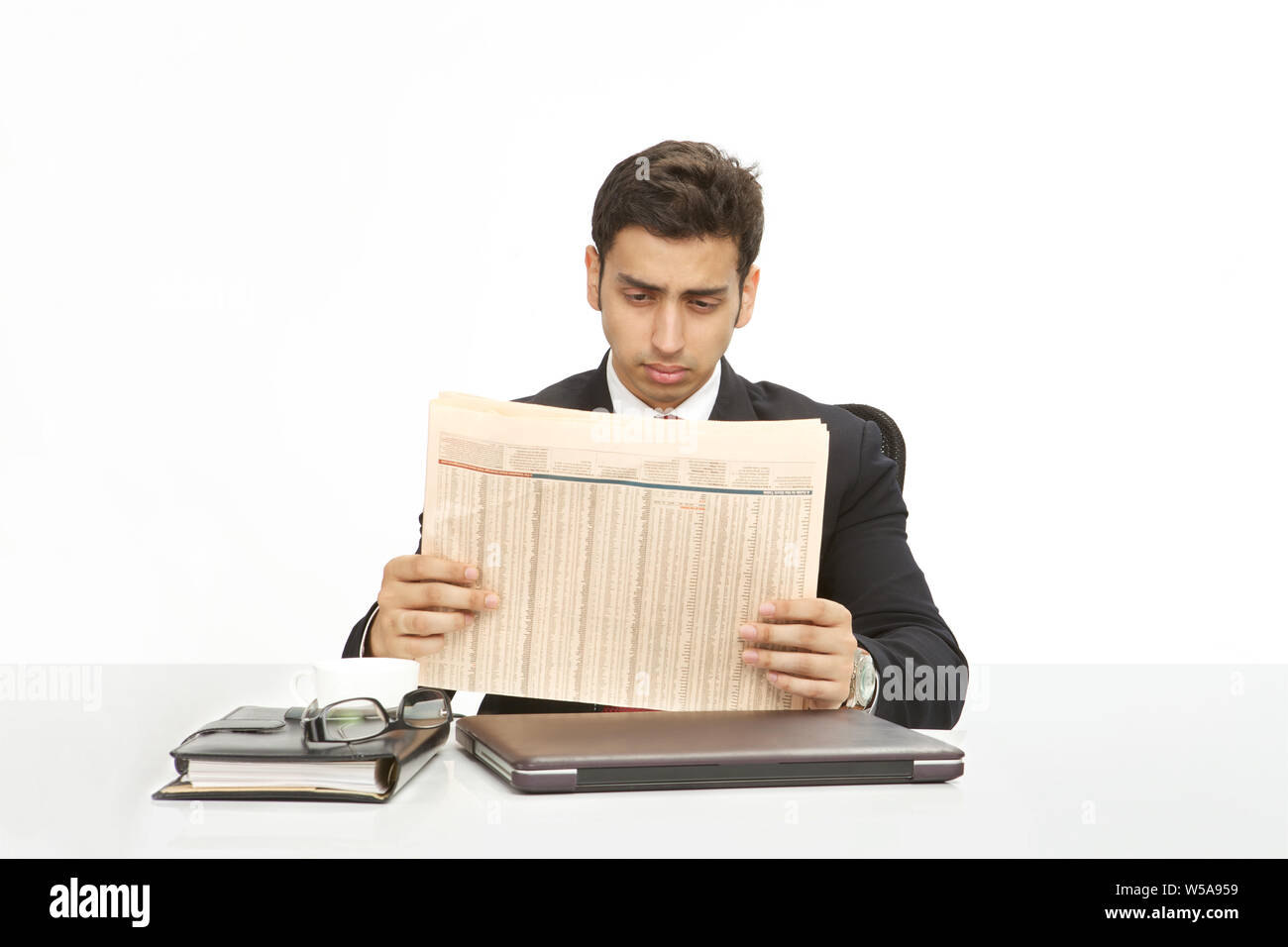Businessman reading a newspaper Stock Photo - Alamy