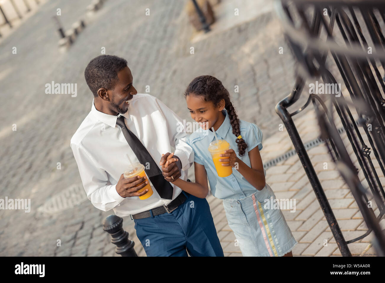 Kind international man looking at his pretty child Stock Photo - Alamy