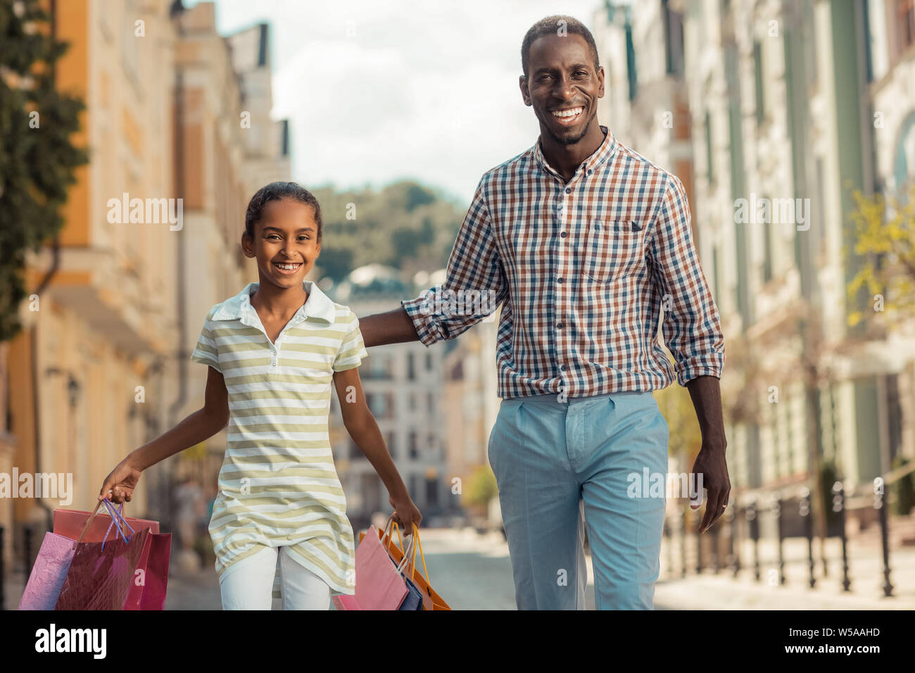 Pretty international girl walking with her daddy Stock Photo - Alamy