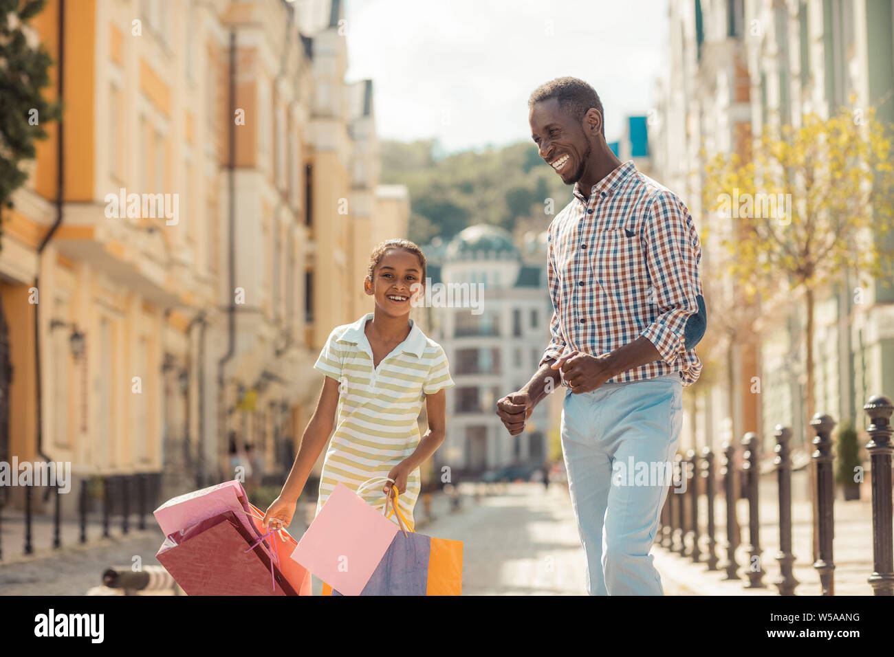 Kind international male person walking with daughter Stock Photo - Alamy