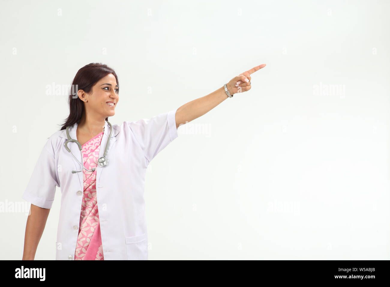 Female doctor pointing and smiling Stock Photo - Alamy