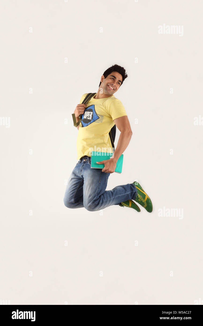 College student jumping and smiling Stock Photo - Alamy