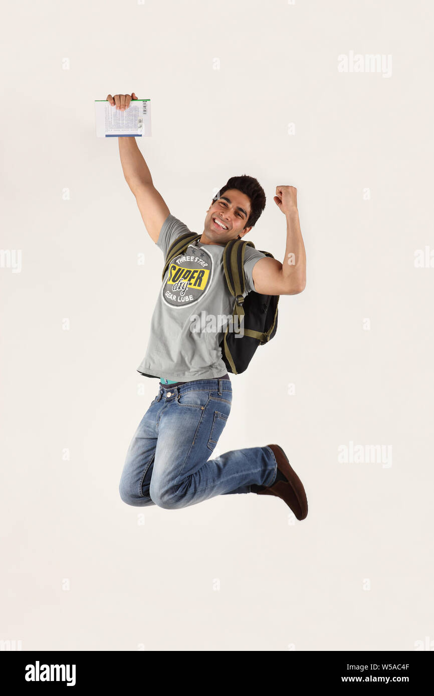 College student jumping in air and smiling Stock Photo - Alamy