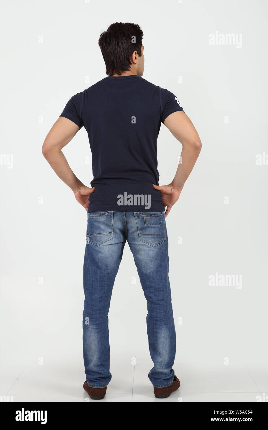 Rear view of a man standing with his arms akimbo Stock Photo - Alamy