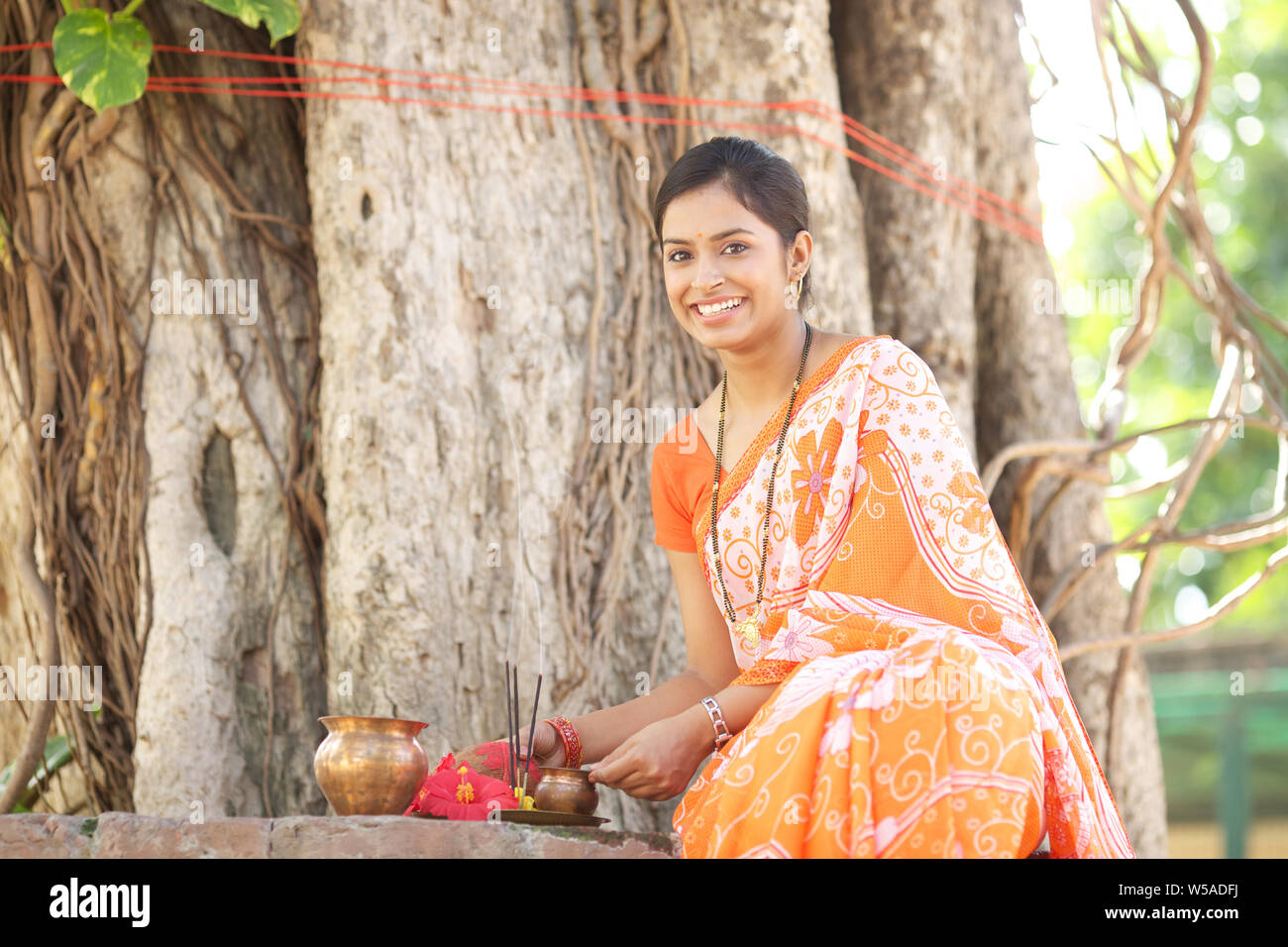 Woman worshipping a sacred tree and smiling Stock Photo - Alamy
