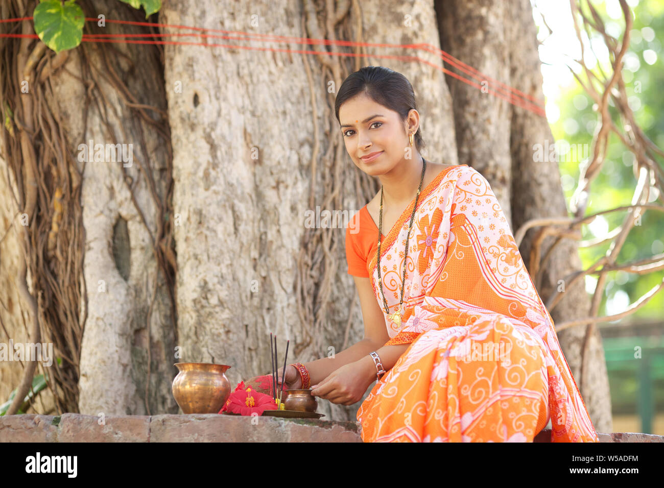 Woman worshipping a sacred tree Stock Photo - Alamy