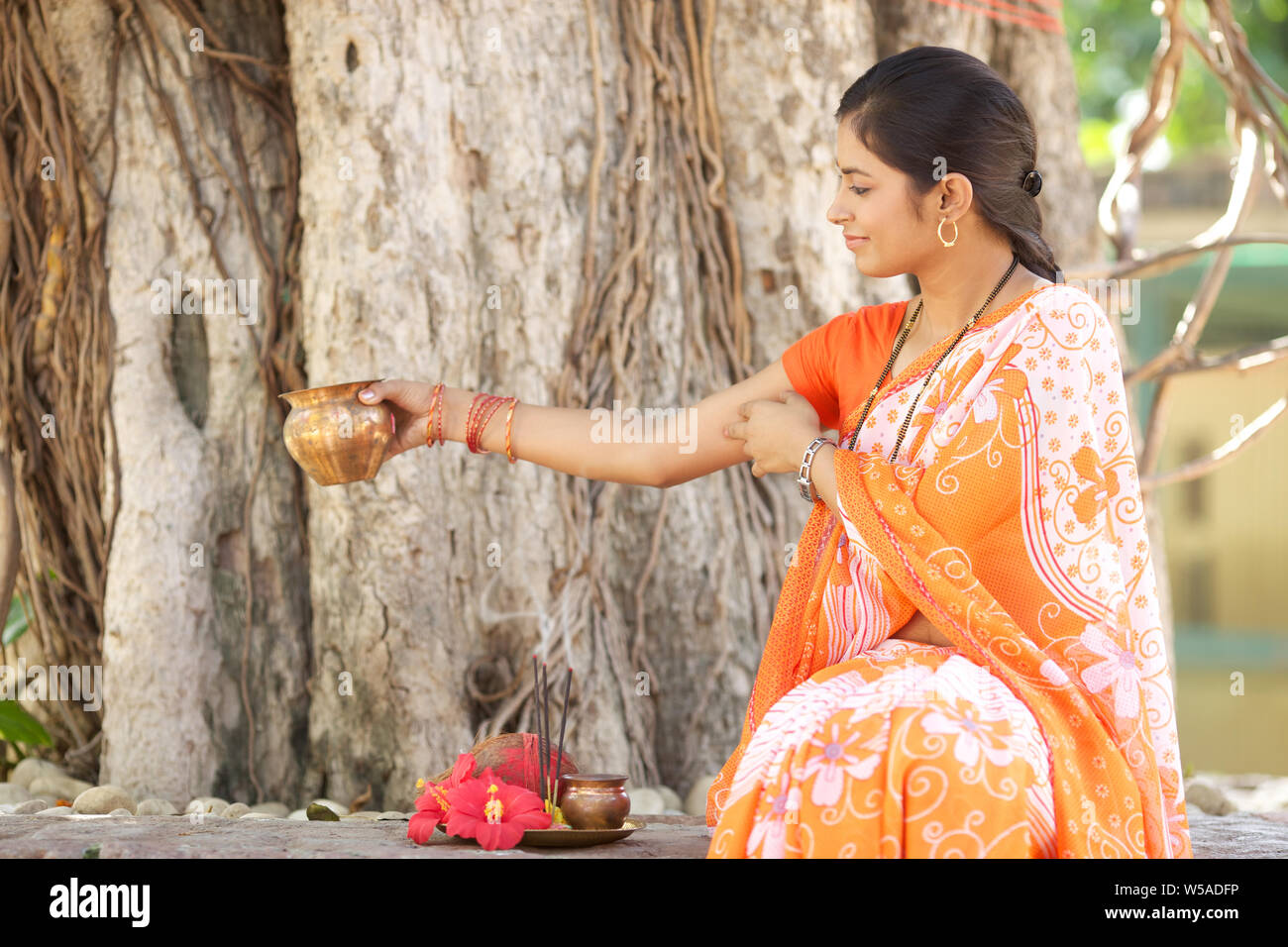 Woman worshipping a sacred tree Stock Photo - Alamy