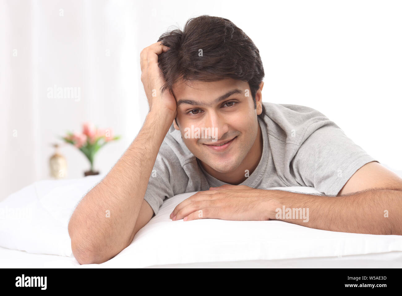 Man lying on bed and smiling Stock Photo - Alamy