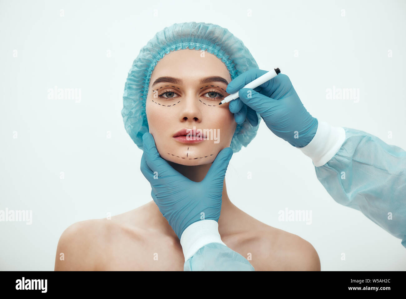 Perfect face. Beautiful and young woman in blue medical hat waiting for ...