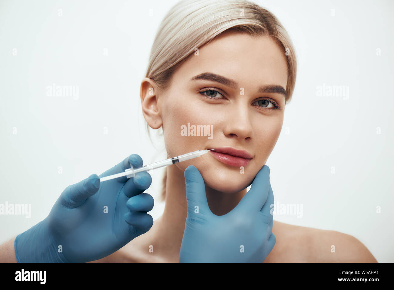 Cosmetic injection. Young beautiful woman looking at camera and smiling ...