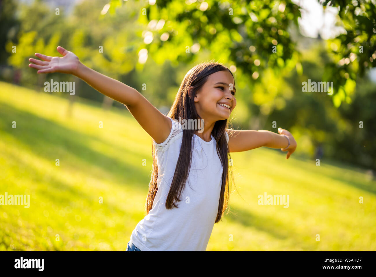 Happy little girl is enjoying nature in park Stock Photo - Alamy