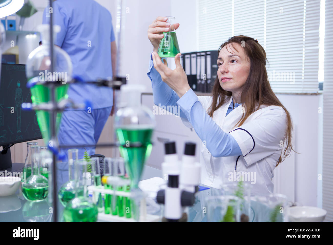 Mature female scientist making scientific test in her research lab ...