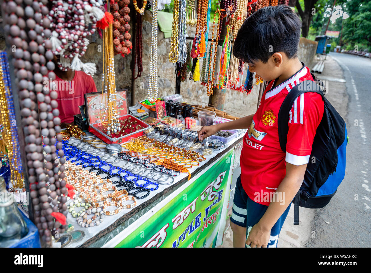 A young boy purchases souvenirs from a street vendor in the spiritual ...