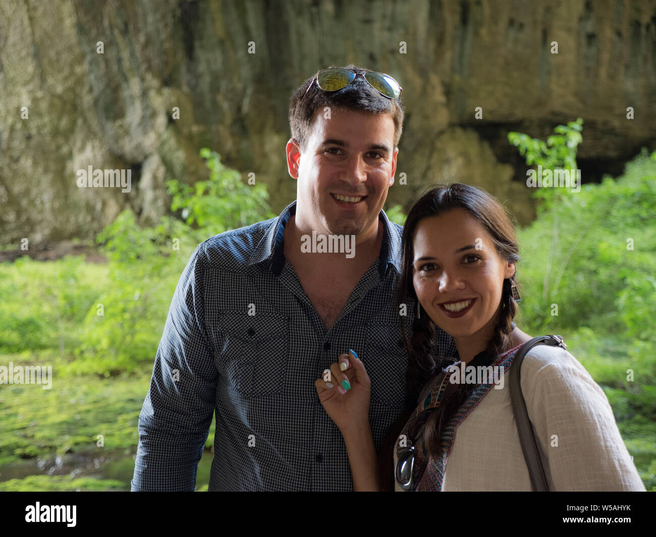 Beautiful young couple smiling to the camera in a mountain cave. Couple ...