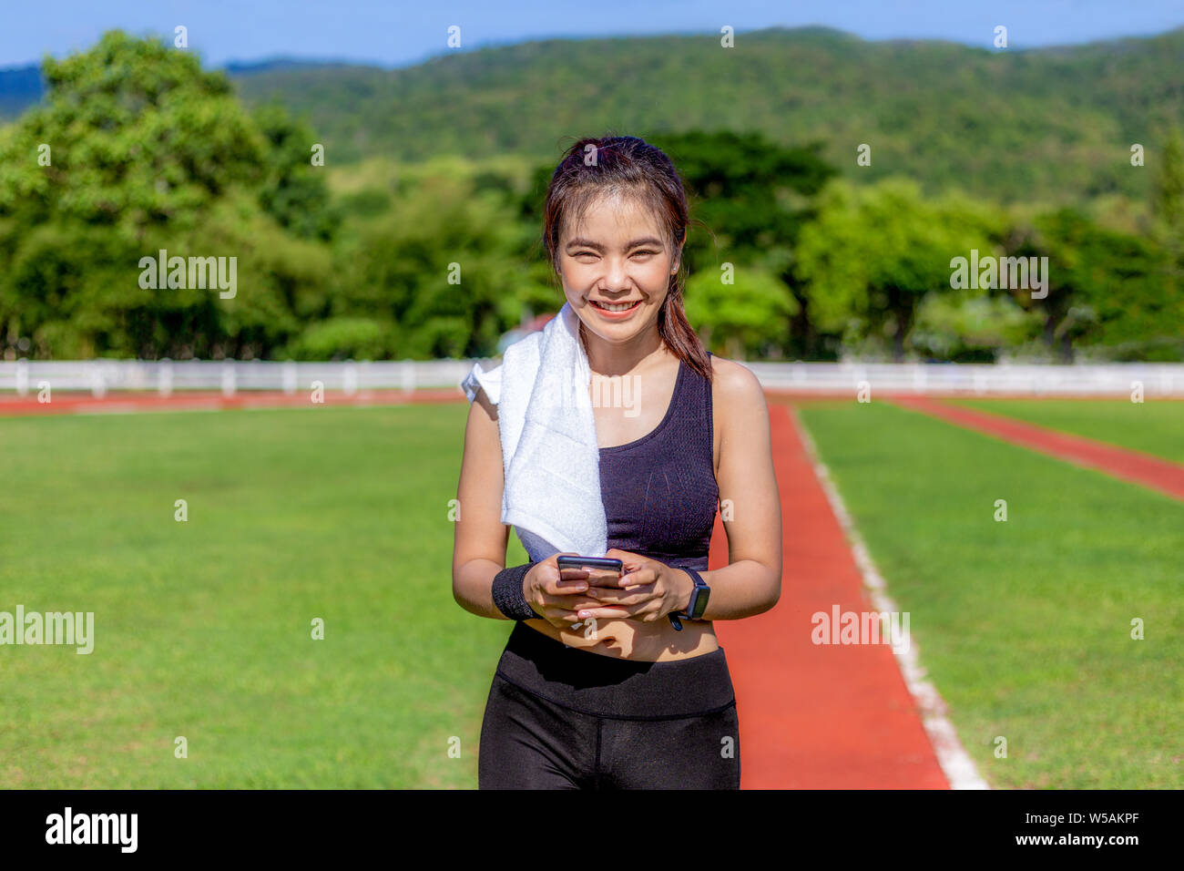 Happy beautiful young Asian woman using her smart phone during ...