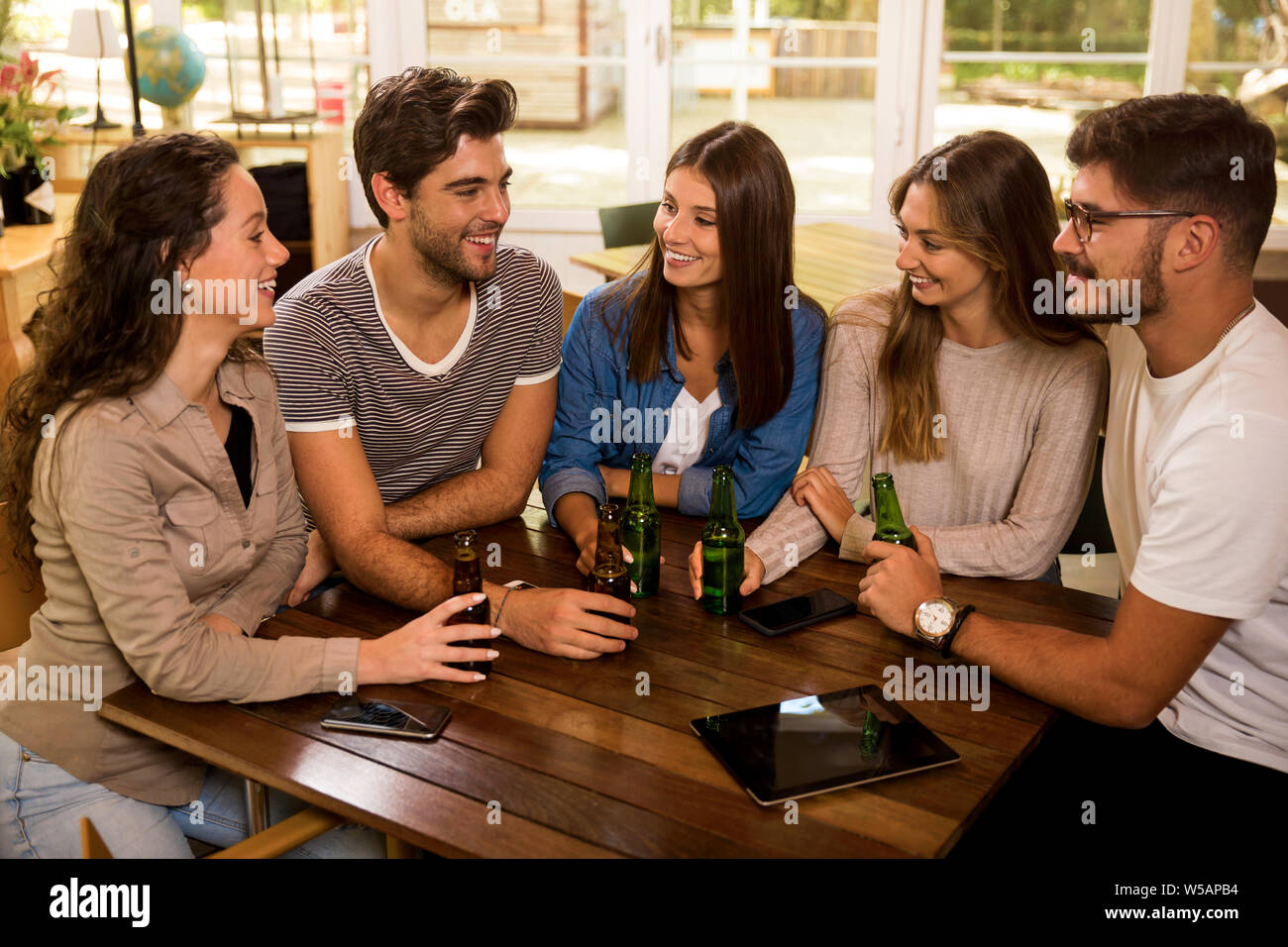 A group of friends at the bar drinking a beer Stock Photo - Alamy