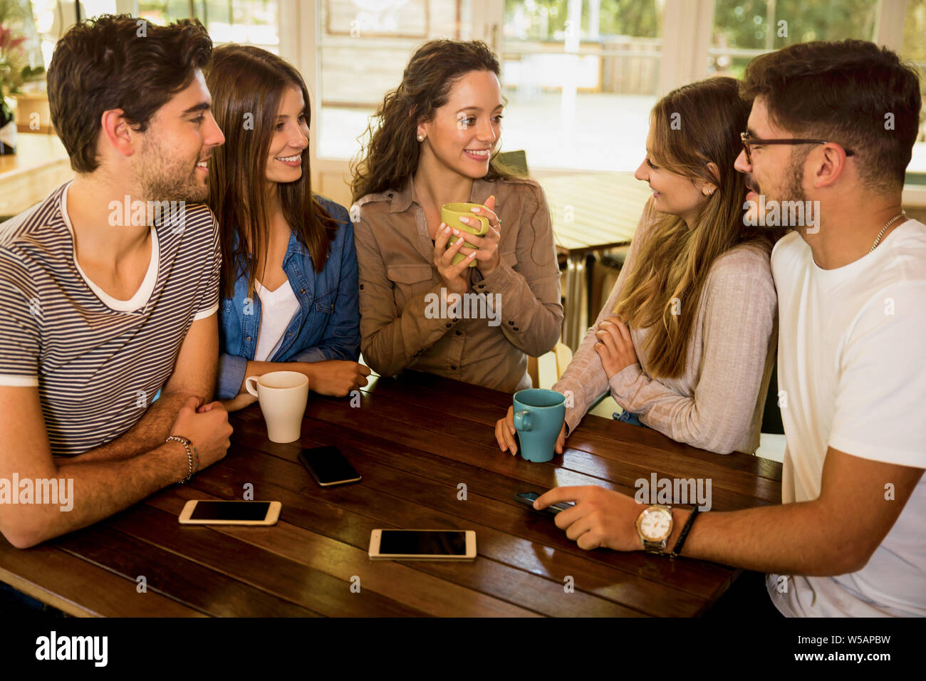 A group of friends talking and drinking coffee at the cafe Stock Photo ...