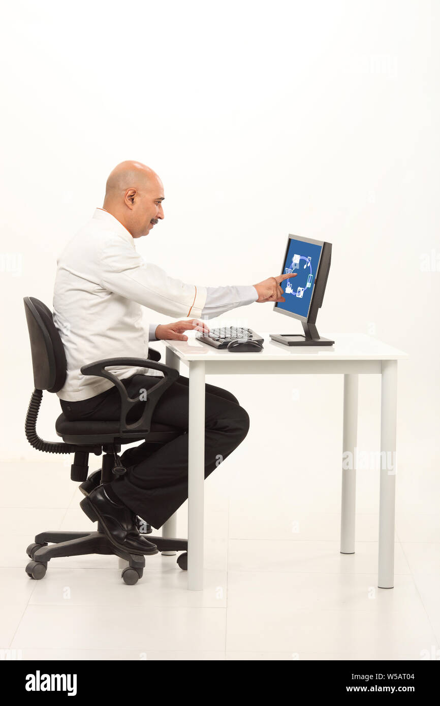 Man working on a desktop pc and pointing Stock Photo - Alamy