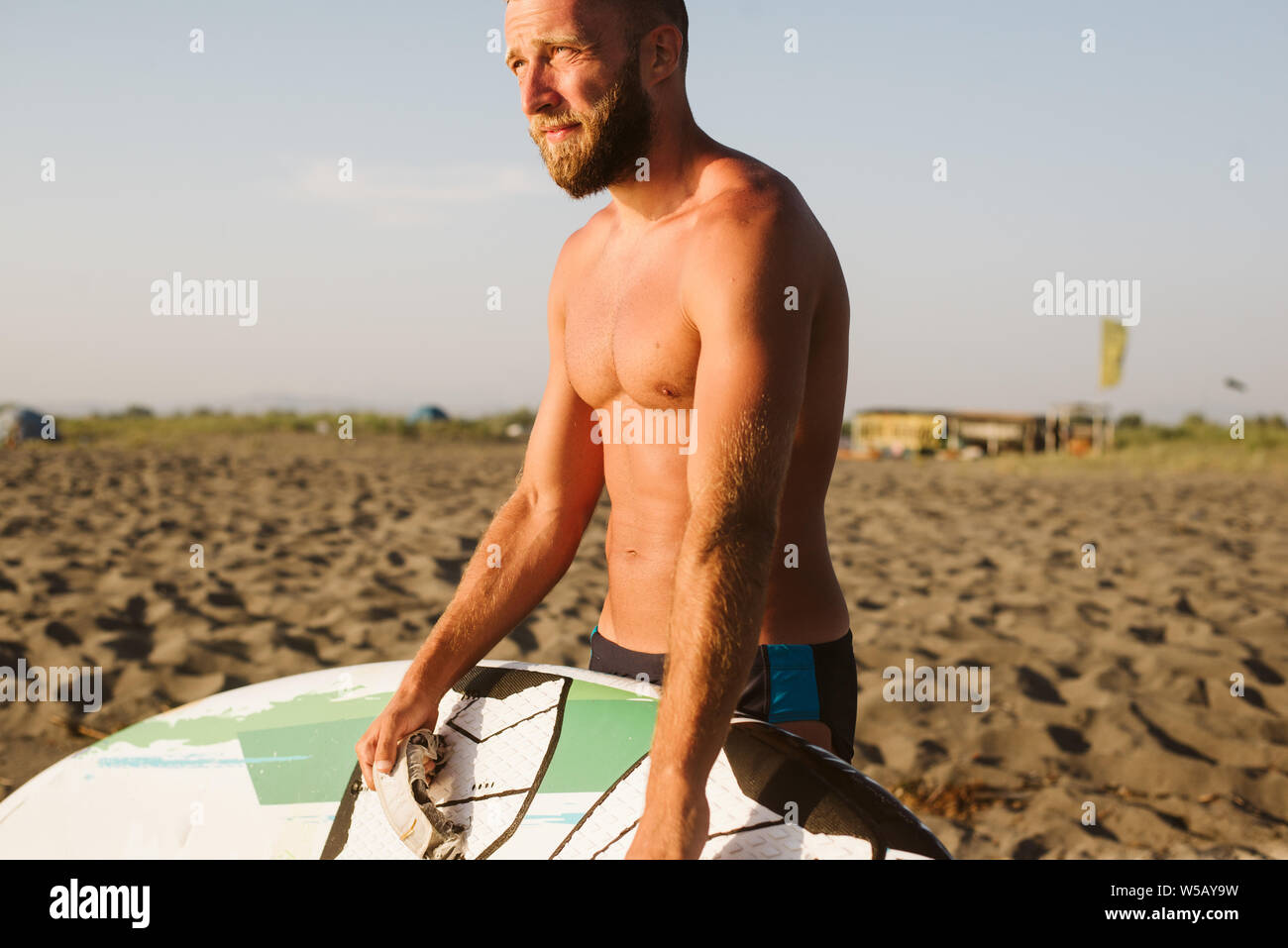 Portrait of confident man with surfboard at beach Stock Photo - Alamy