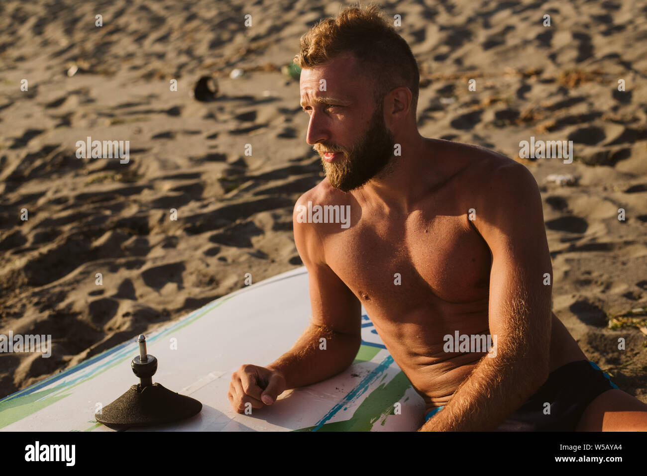 Portrait of confident man with surfboard at beach Stock Photo - Alamy