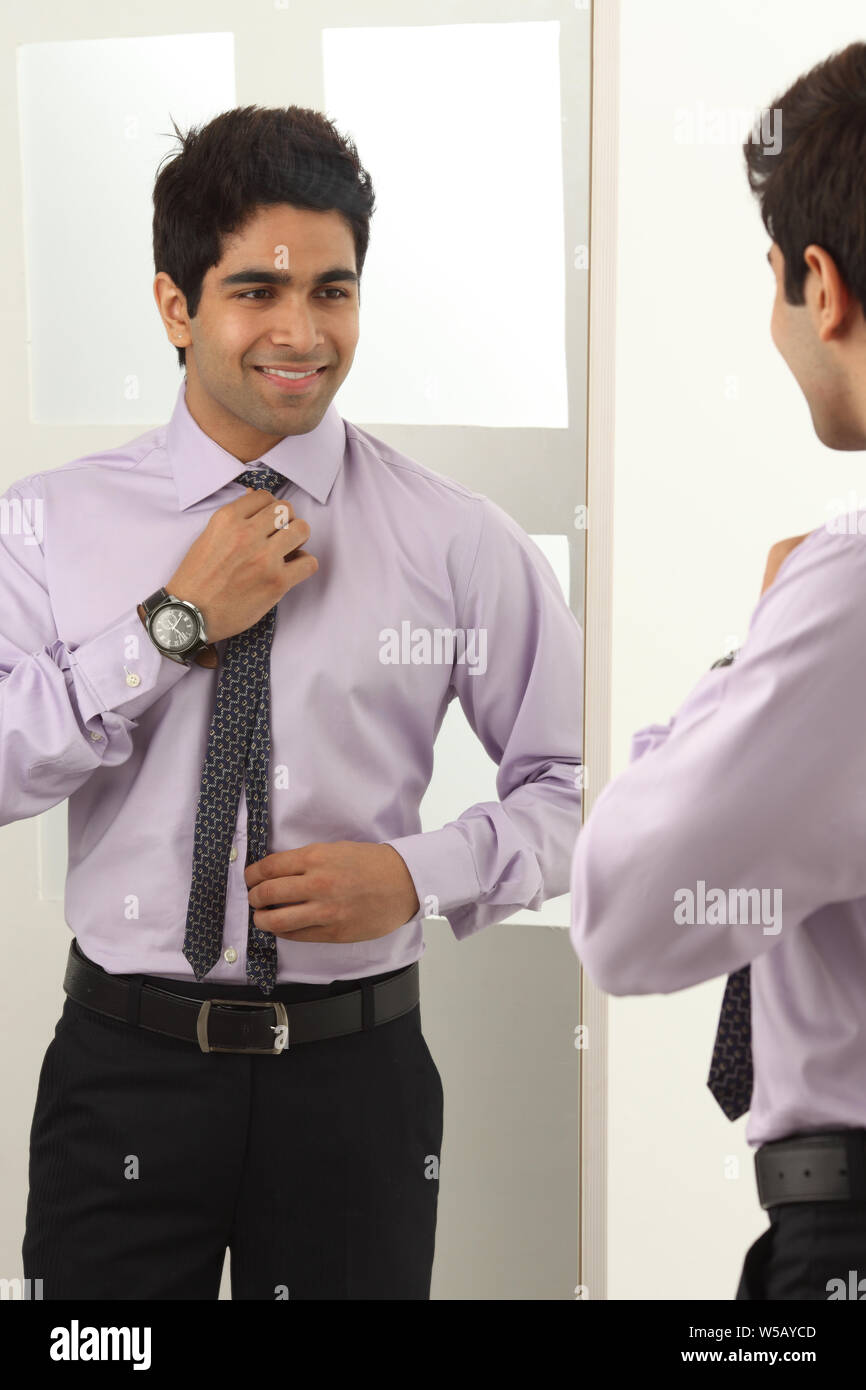 Man putting on tie mirror hi-res stock photography and images - Alamy