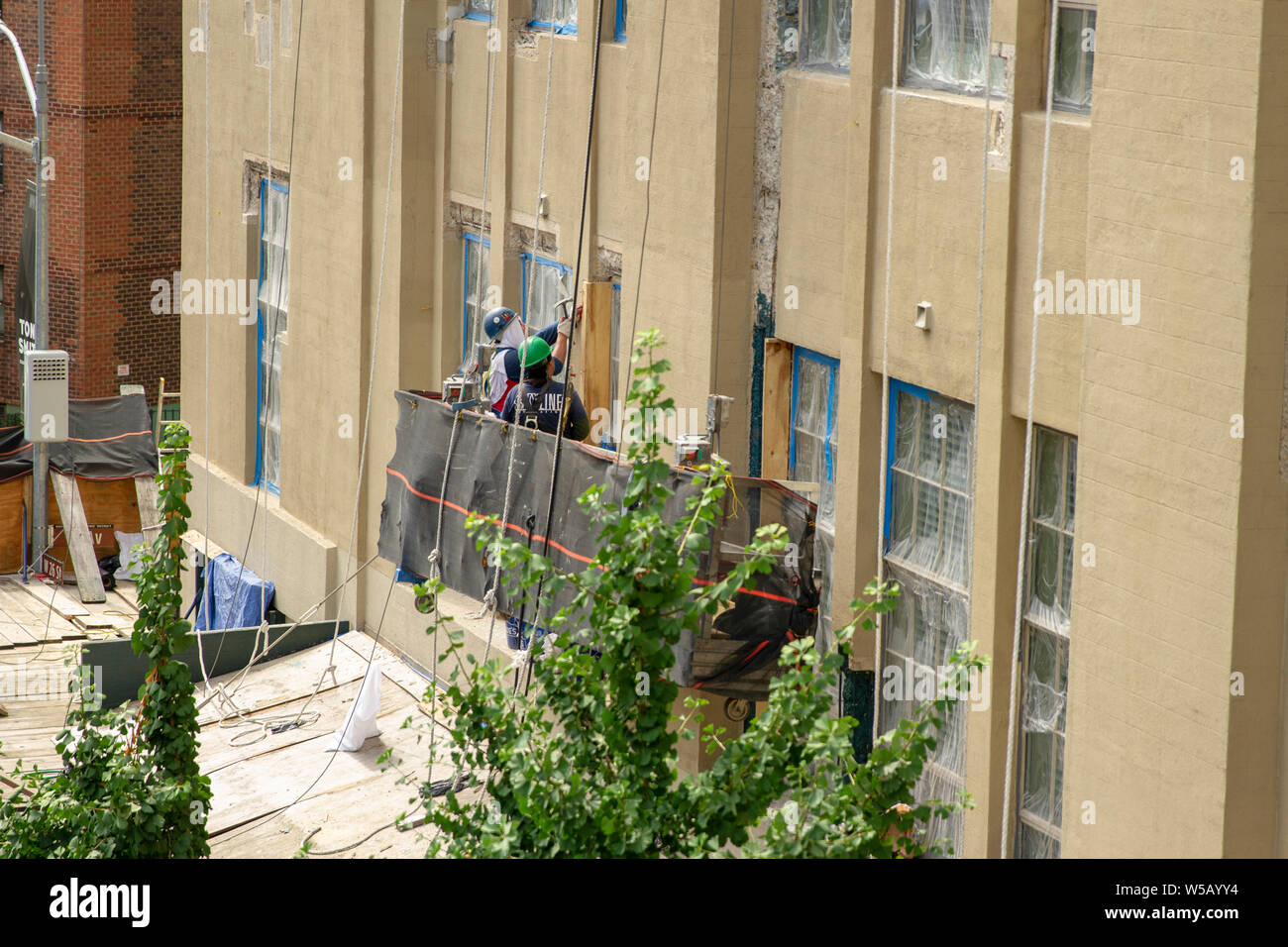 Men on a hanging platform Stock Photo - Alamy