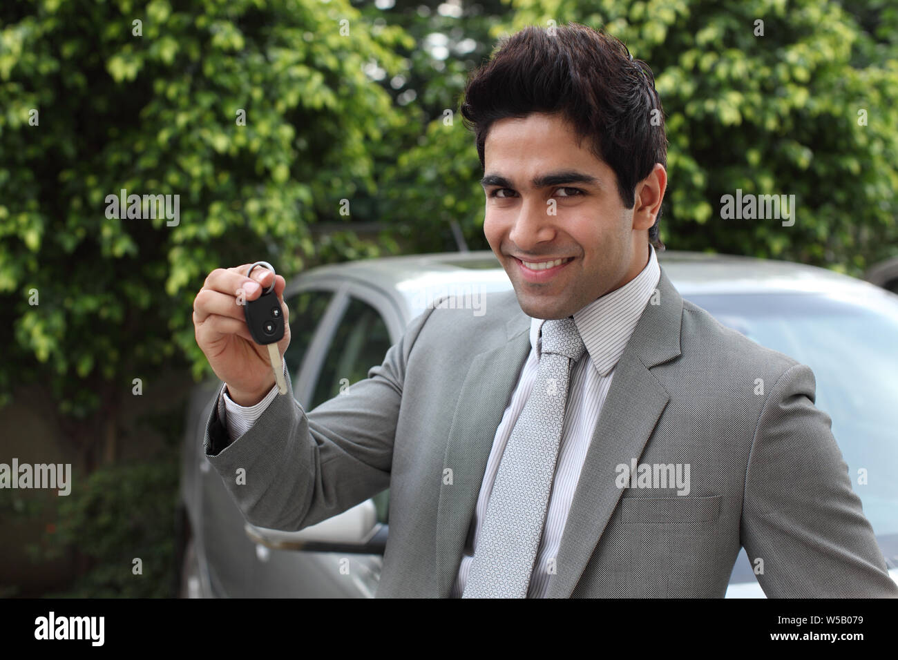 Businessman showing a new car key and smiling Stock Photo - Alamy