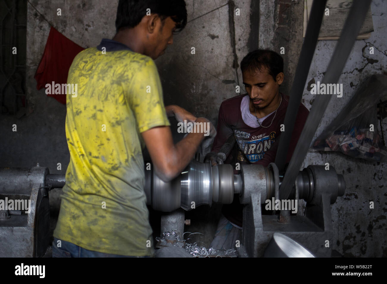 Labors working on a sliver cooking pot factory in Dhaka, Bangladesh ...