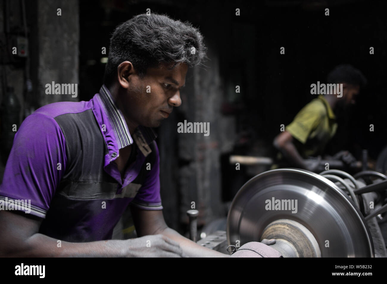 Labors working on a sliver cooking pot factory in Dhaka, Bangladesh ...
