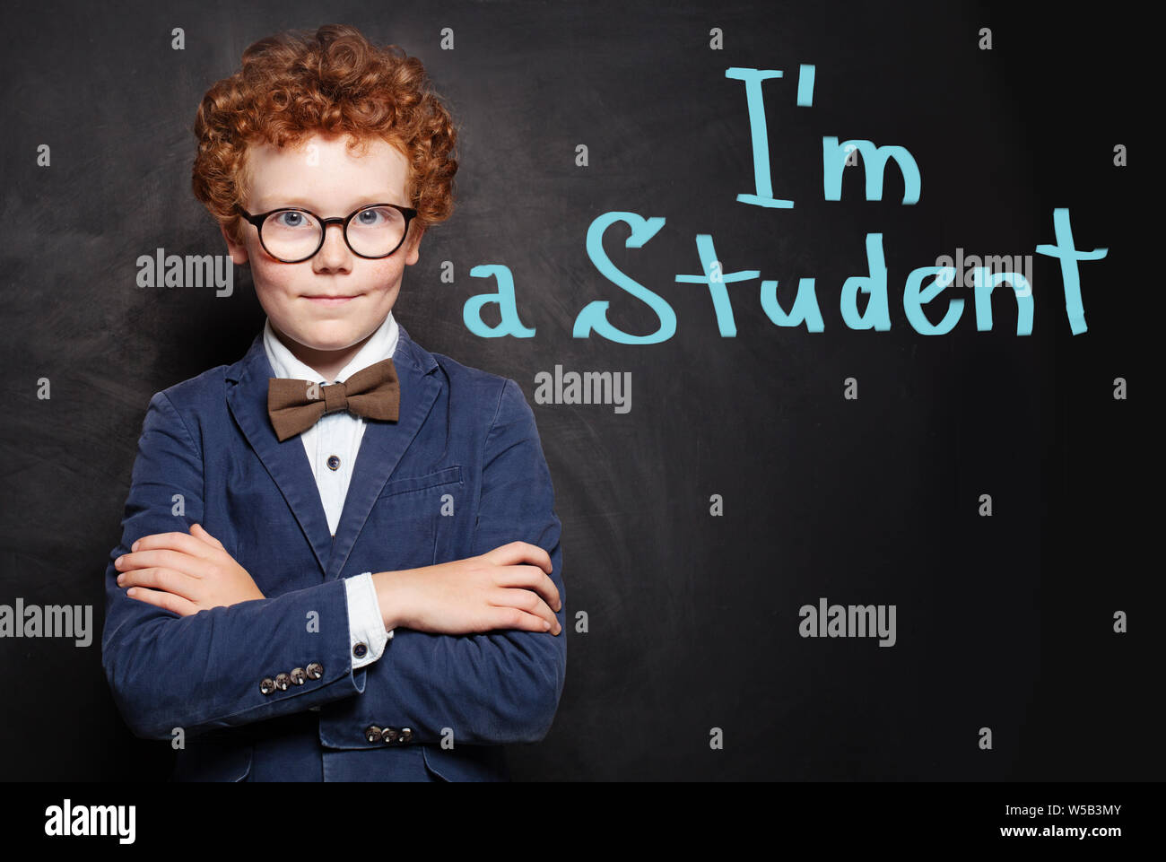Smart child student in suit on chalkboard background Stock Photo - Alamy