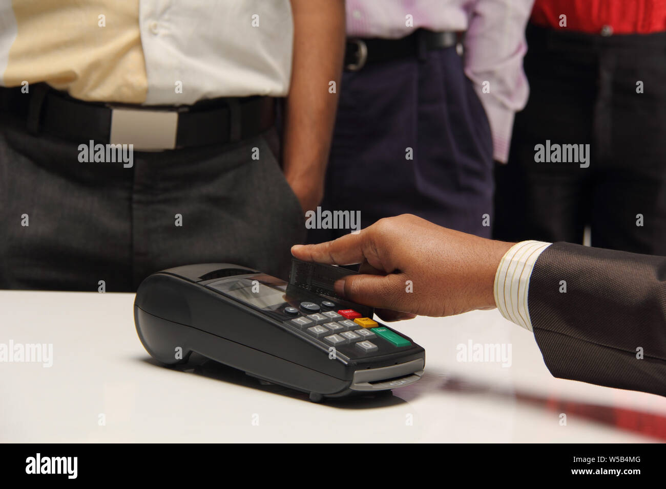 Shop assistant swiping credit card through machine Stock Photo - Alamy
