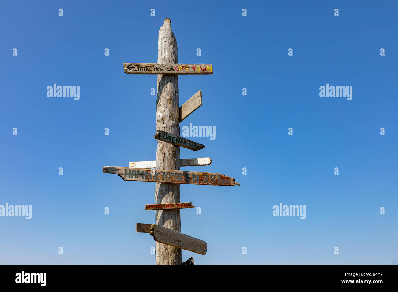 wooden and multicolored travel traffic signpost pointing from Sweden ...