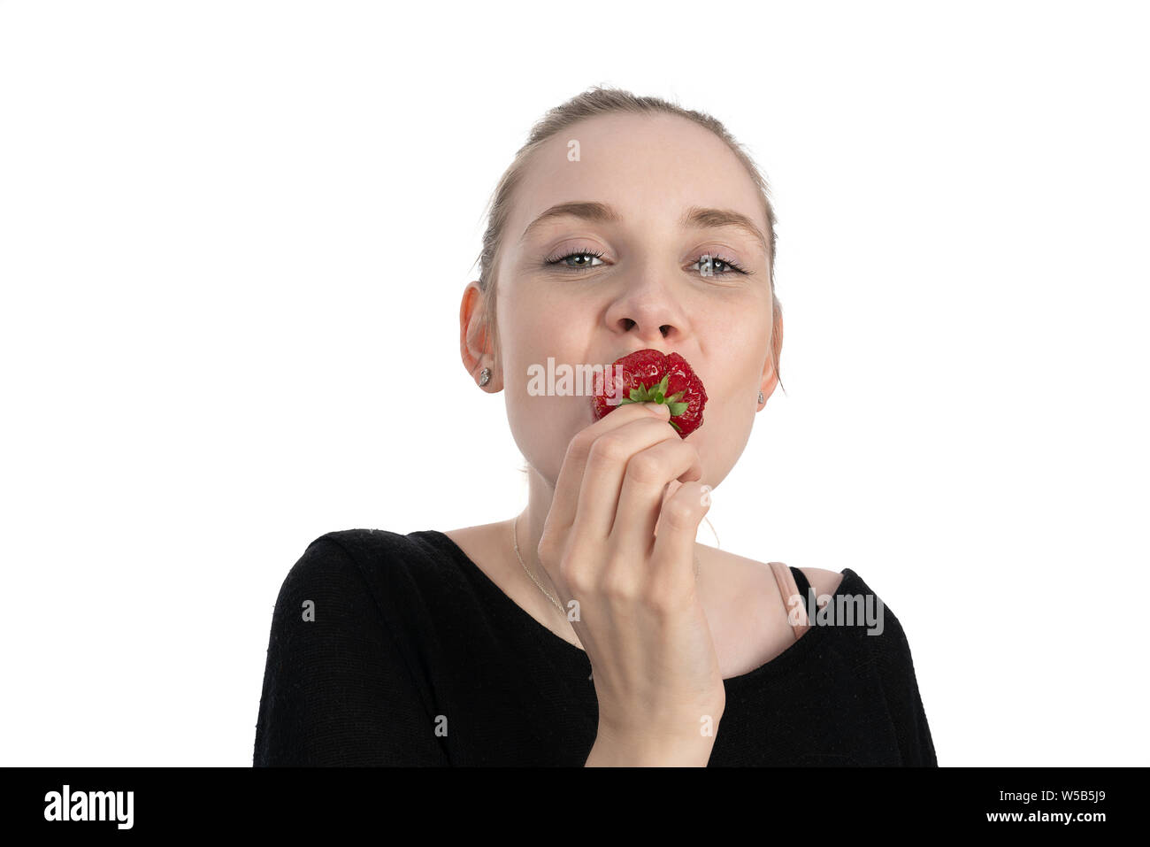 a young woman is enjoying to eat a strawberry Stock Photo - Alamy