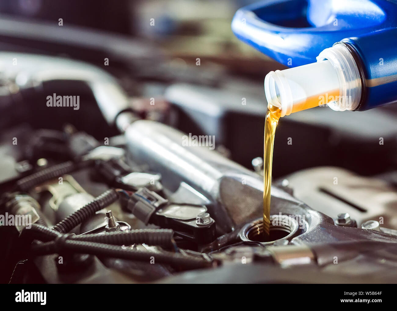 Motor oil pouring to car engine. Repair service Stock Photo - Alamy