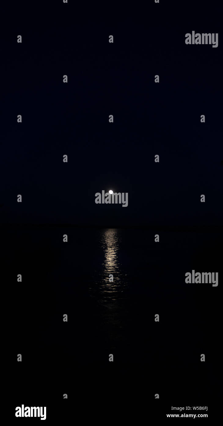 the moon and the light shining on the water Stock Photo - Alamy